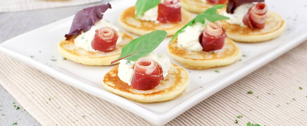 Blinis con jamón y brotes tiernos